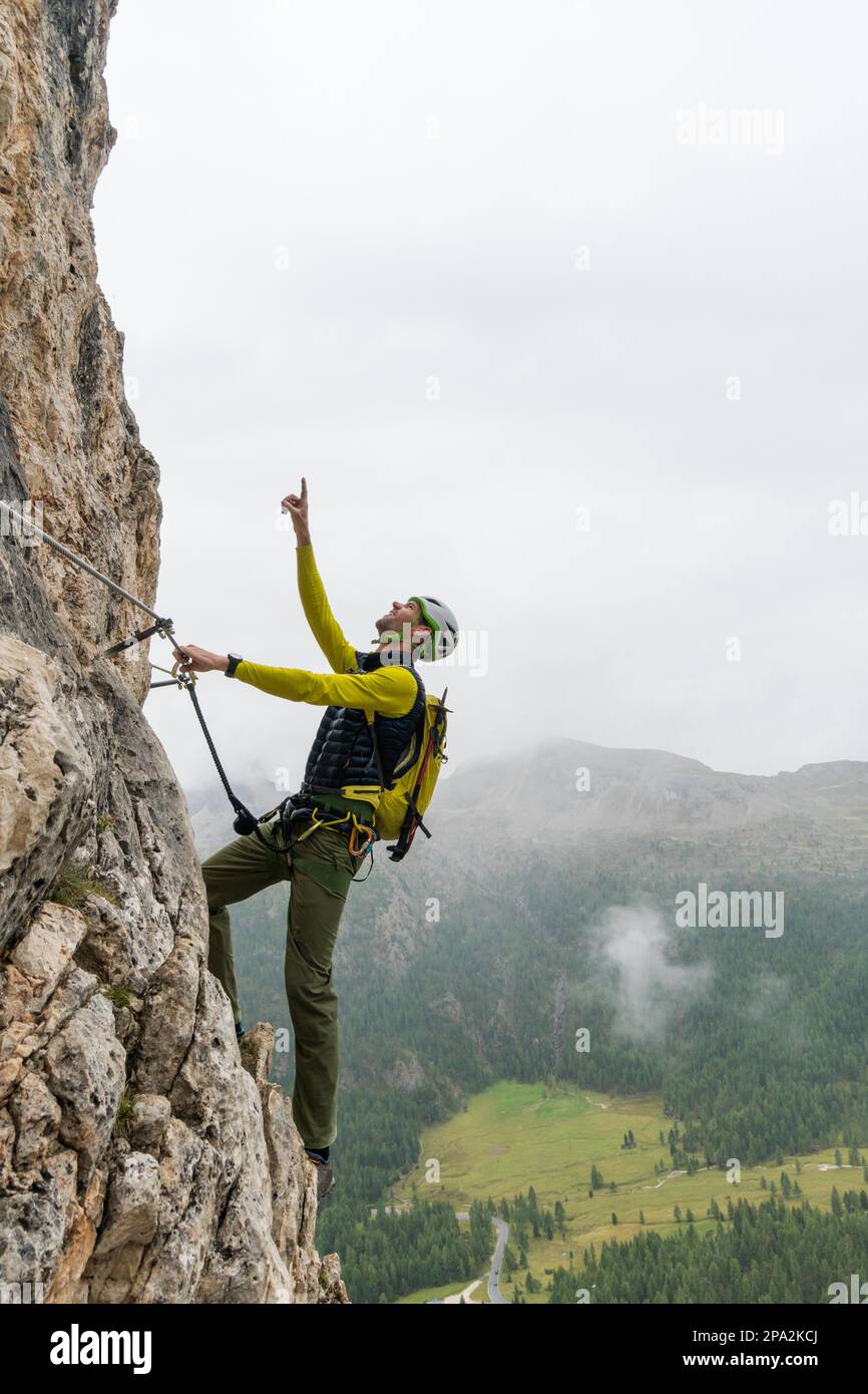 Young attractive male mountain climber on a steep and exposed Via ...