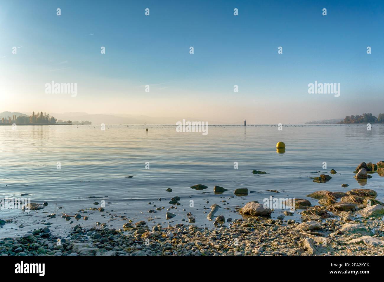 Calm lakeside shore view of a blue Lake Zurich in Switzerland with ...