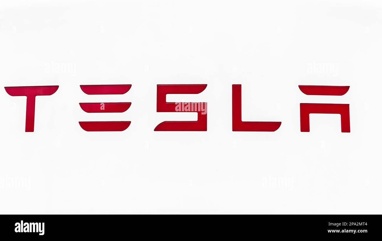 Red Tesla lettering on white background, company logo on a Supercharger ...
