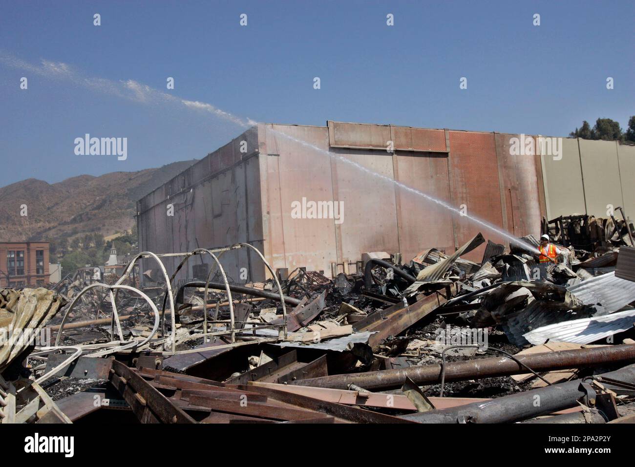 Ted Wayman, a Universal Studios' worker, hoses down the area outside ...