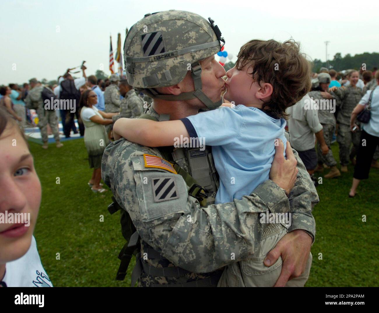 U.S. Army Lt. Col. Steve Fischer, left, kisses his youngest son Alex ...