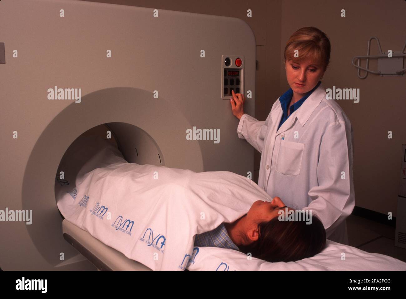 Medical technician prepares a patient for an MRI scan at a New York ...