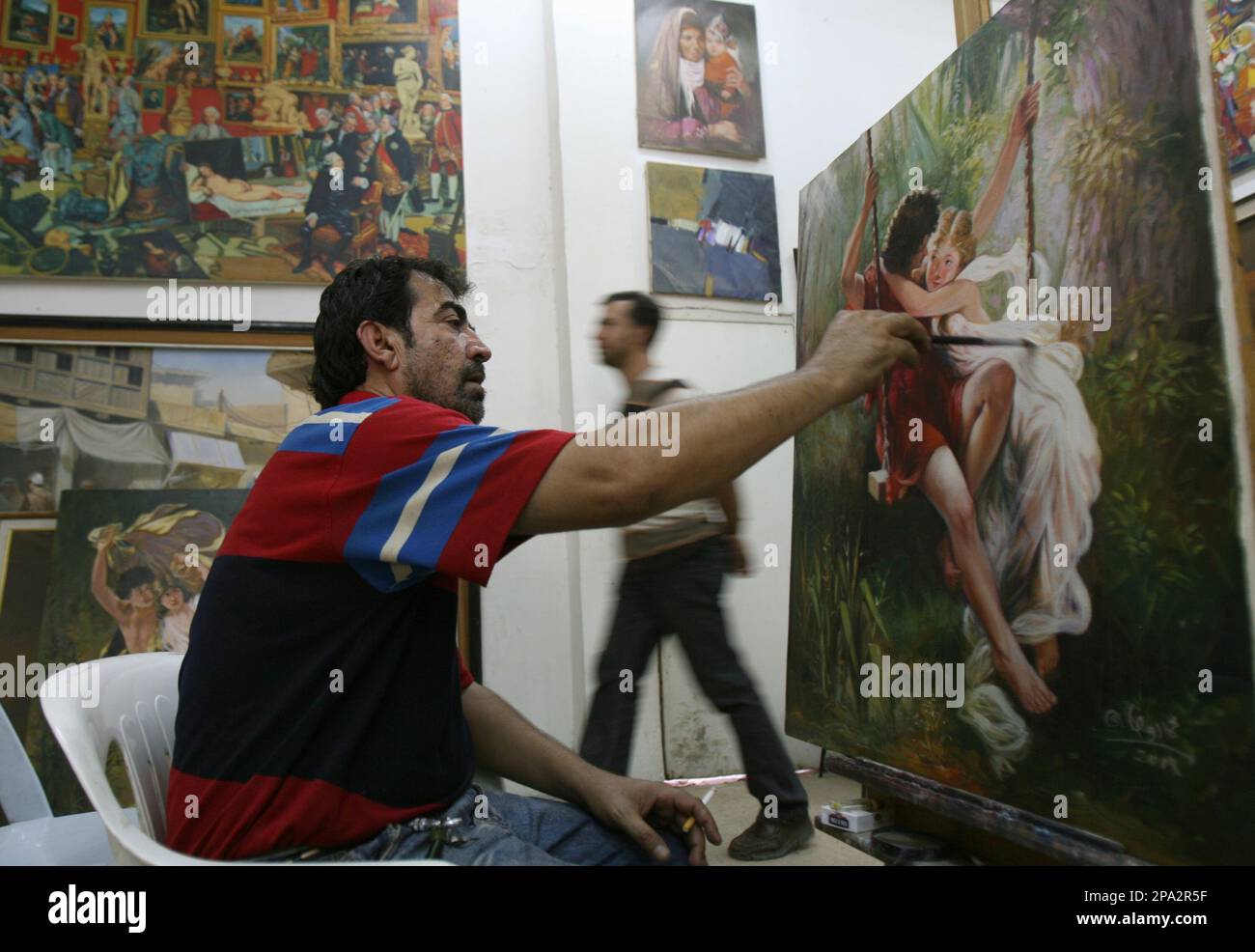 An artist paints at a gallery in Karradah, in downtown Baghdad, Iraq ...