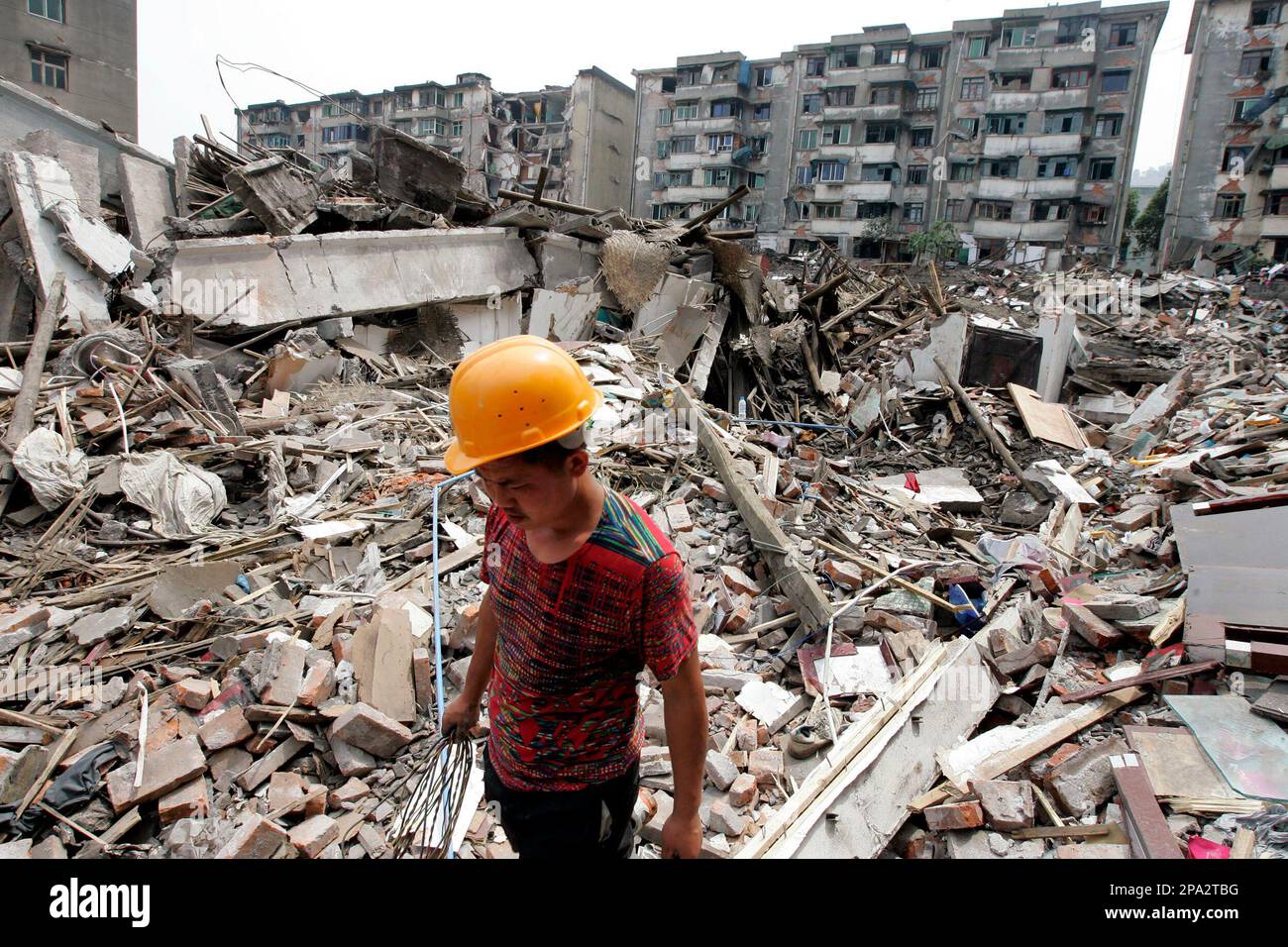 An earthquake survivor looks for anything usable from the rubble of ...