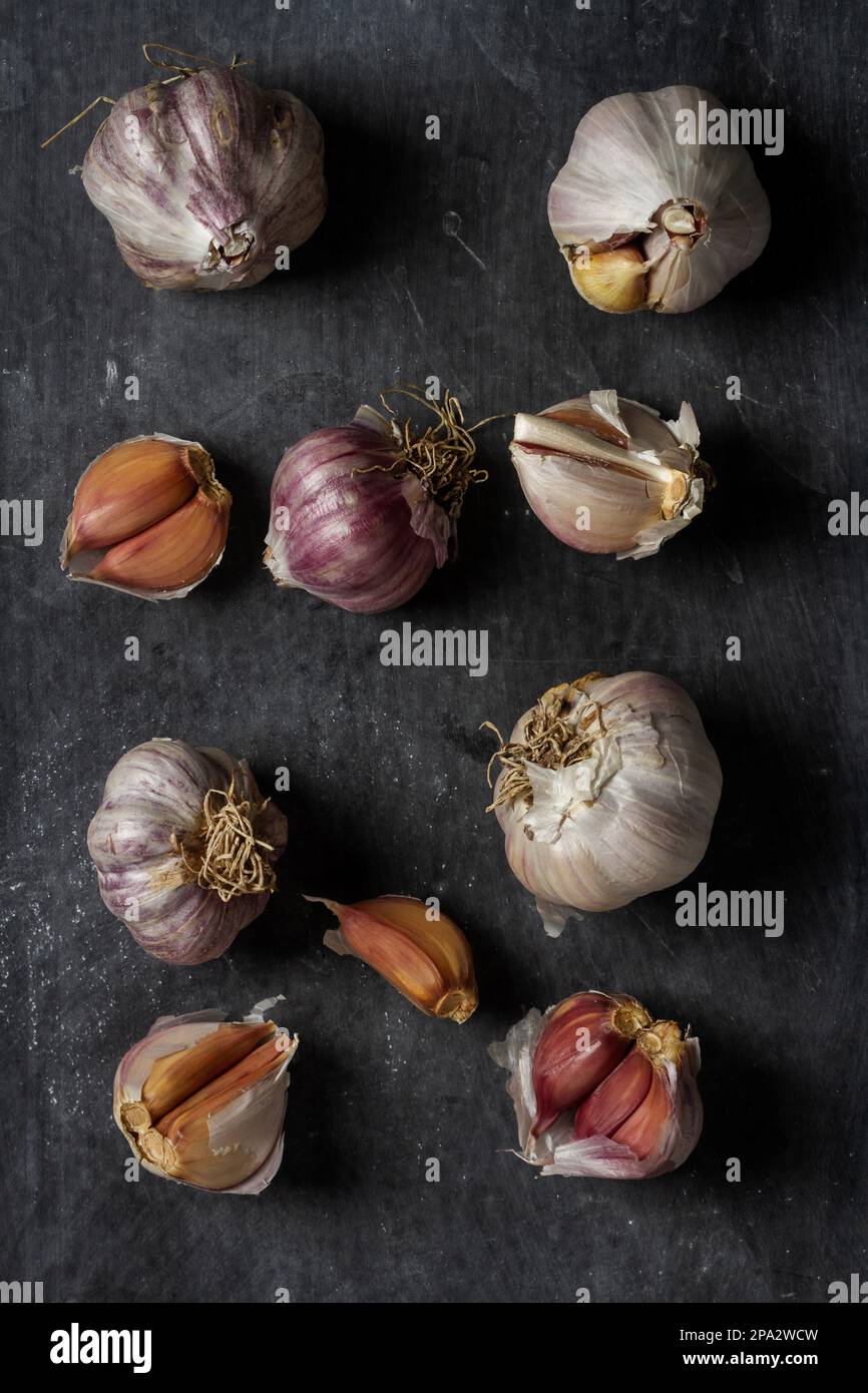 Fresh garlic bulbs and cloves grouped on black background. Flat lay ...