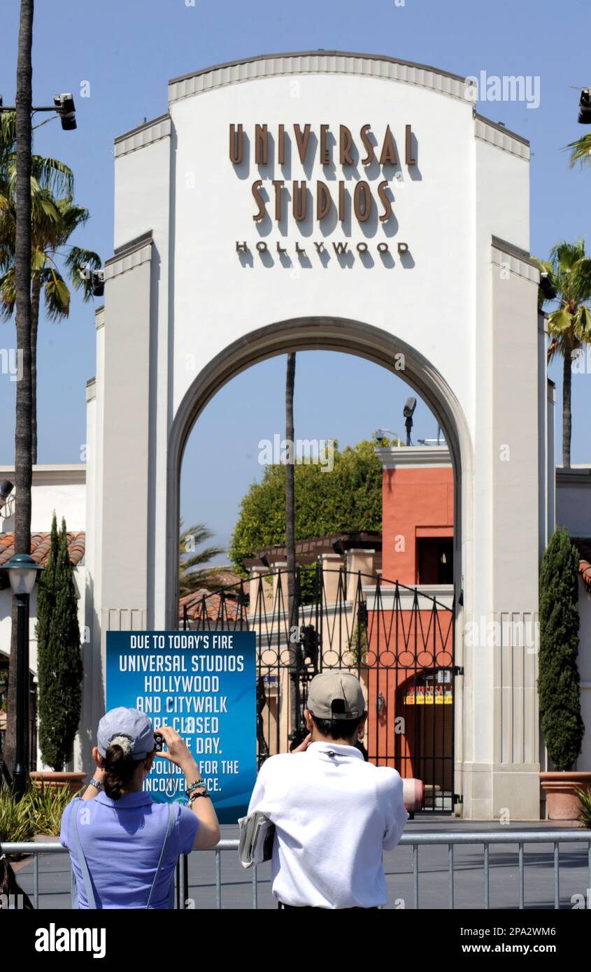 Tourist take a picture of a sign announcing the closing of Universal ...
