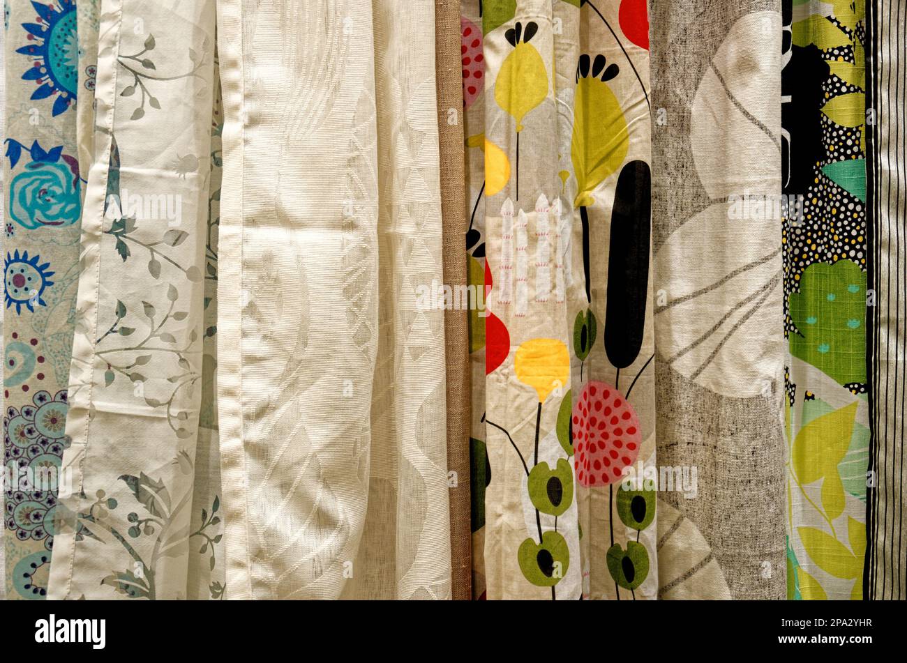 Colorful curtain samples hanging from hangers on a rail in a display in ...