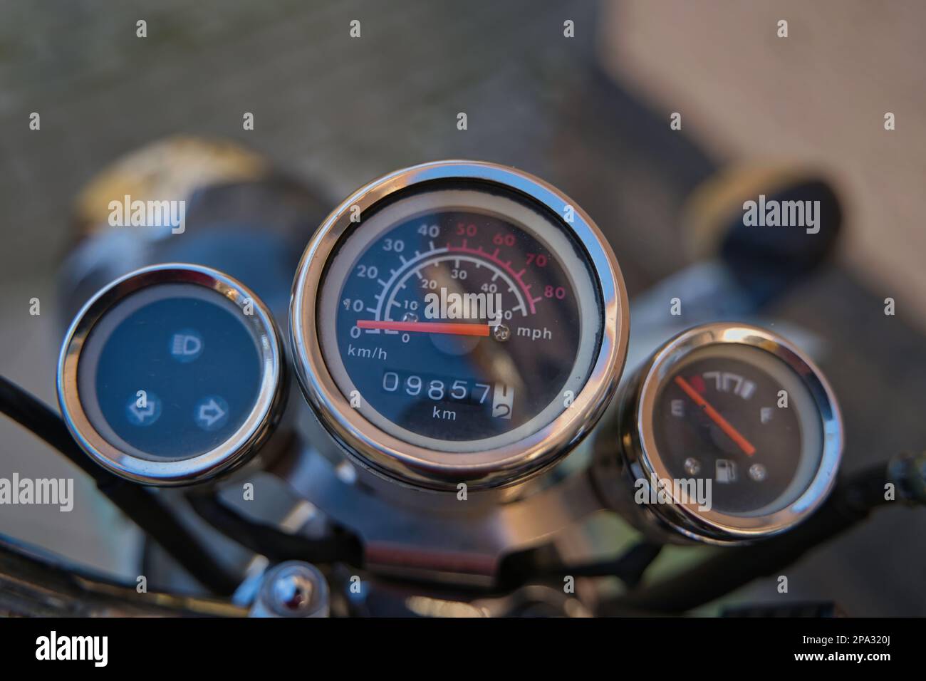 close up of moped dashboard with speedometer cluster against blurred ...