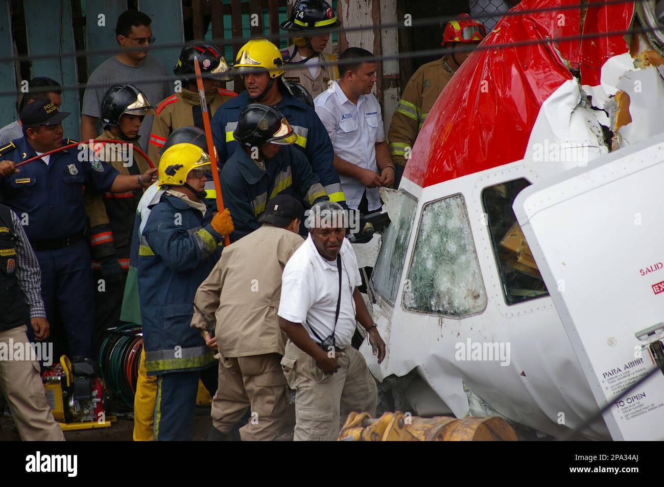 Rescue workers try to extract the pilots from the cockpit after a ...