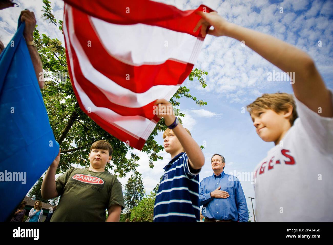 Connor Robertson, left, John Randall, and Andrew Humiston raise a flag ...