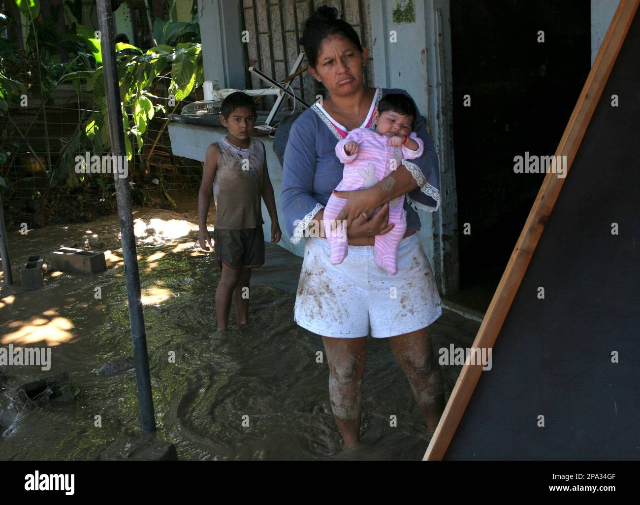 Jackeline Chacon holds her 28 day old baby Surayi, as her son looks on ...