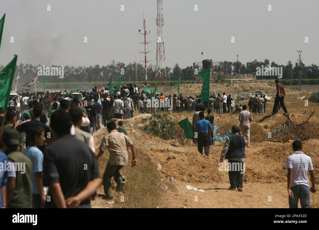 Palestinians march towards an Israeli guard tower at a demonstration ...