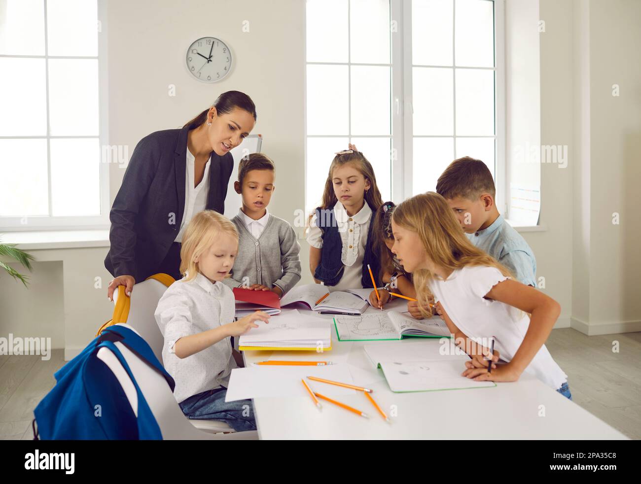 Group of elementary school students with teacher drawing pictures in ...