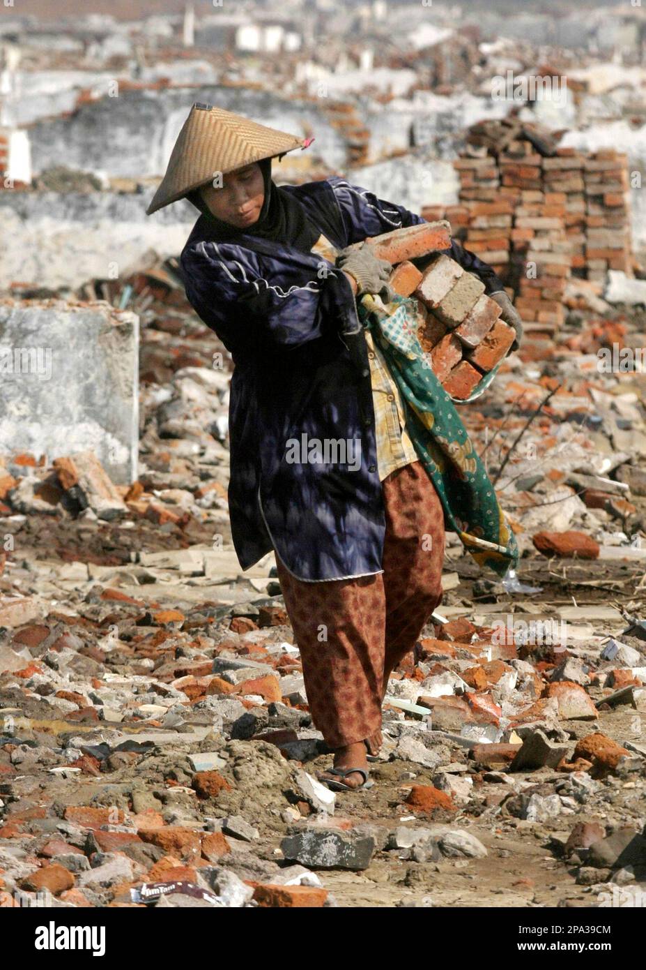An Indonesian woman displaced by an ocean of mud oozing from a mud ...