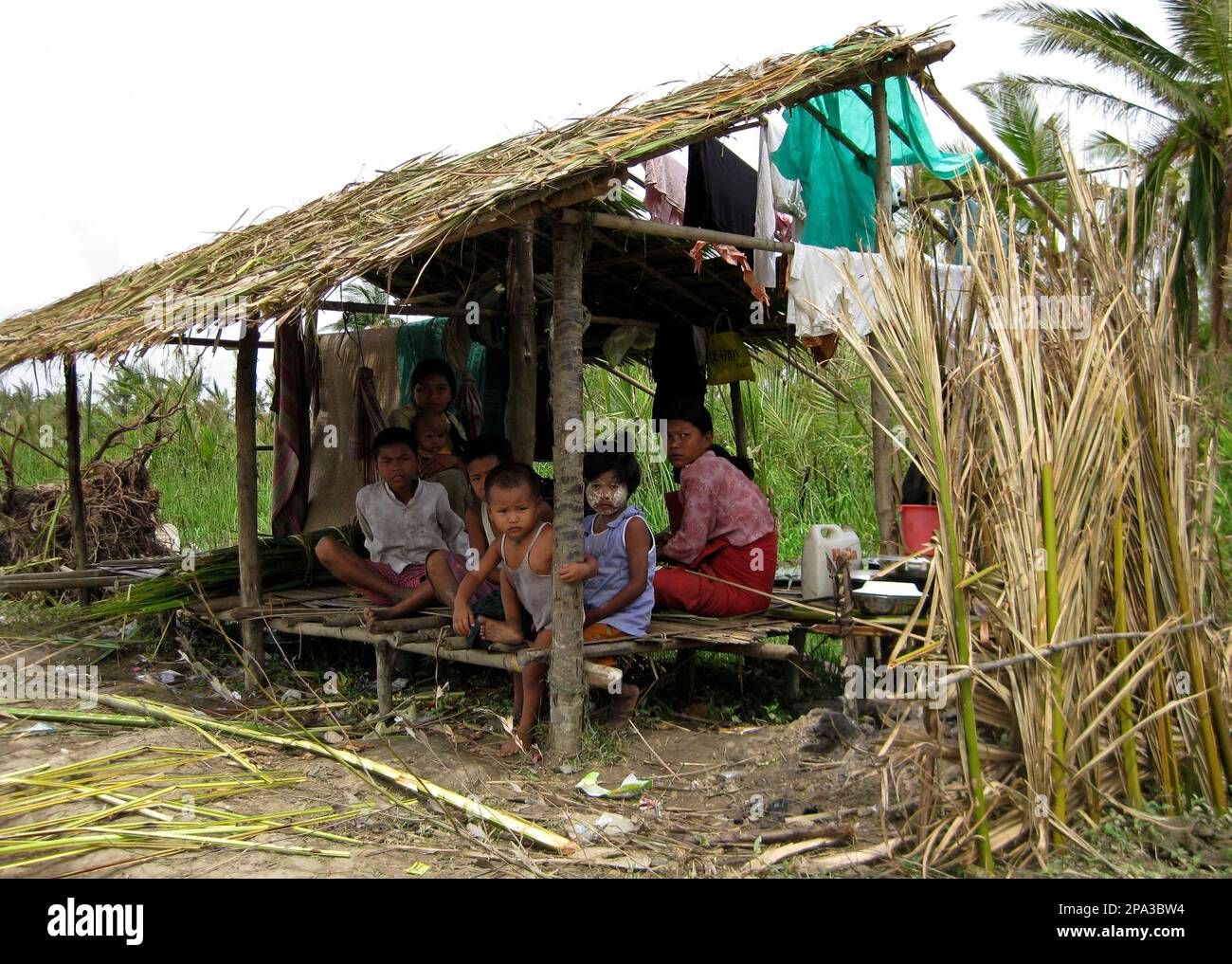 A family of cyclone survivors are seen, in a hut they built for ...