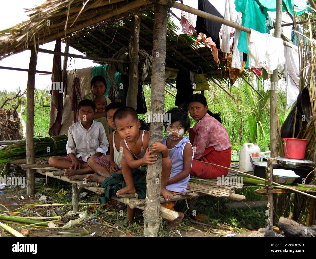 A family of cyclone survivors sit together in a hut they built for ...