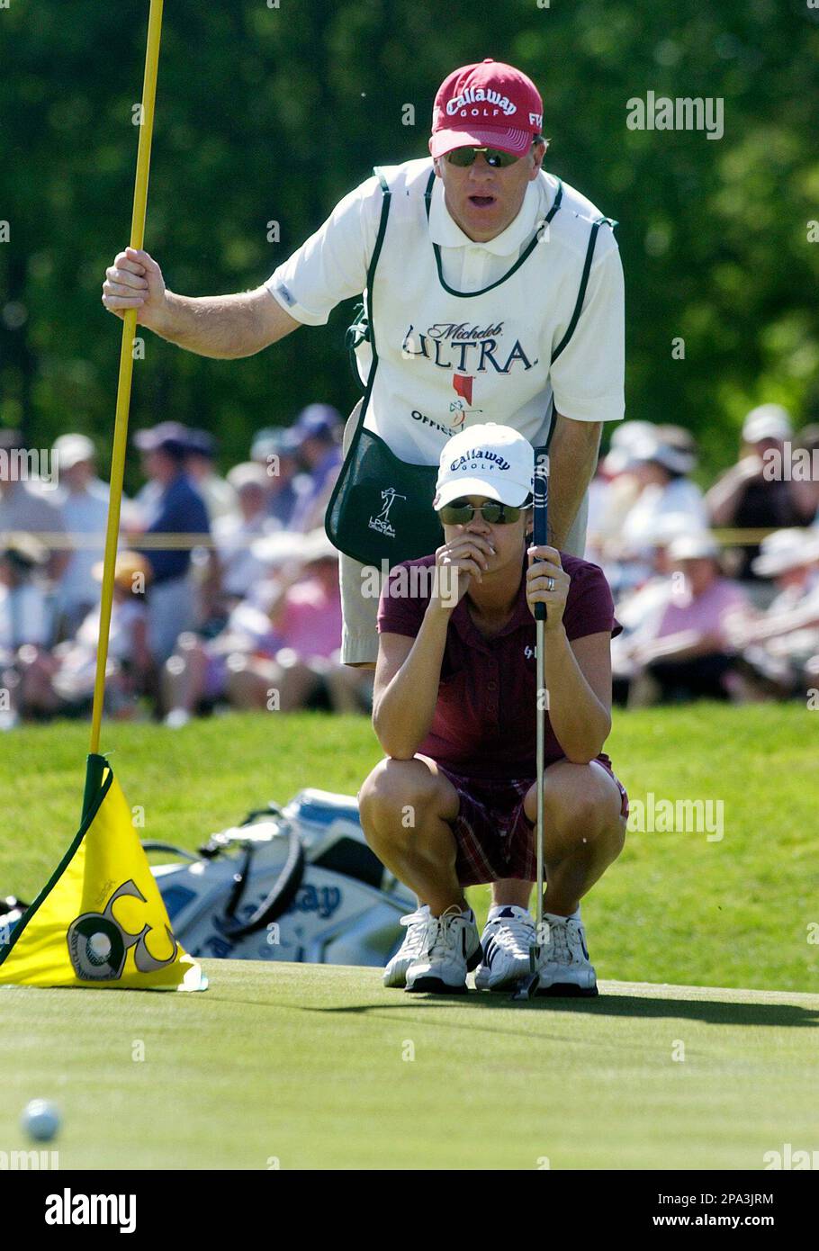 Leta Lindley reads the green with her caddie and husband Matt Plagmann ...