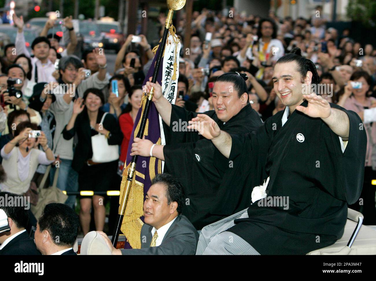 Bulgarian Kotooshu, right, waves from a convertible during a parade ...