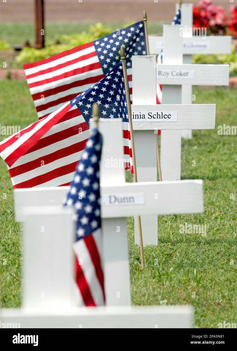 Crosses with names of fallen service men and women line the front lawn ...
