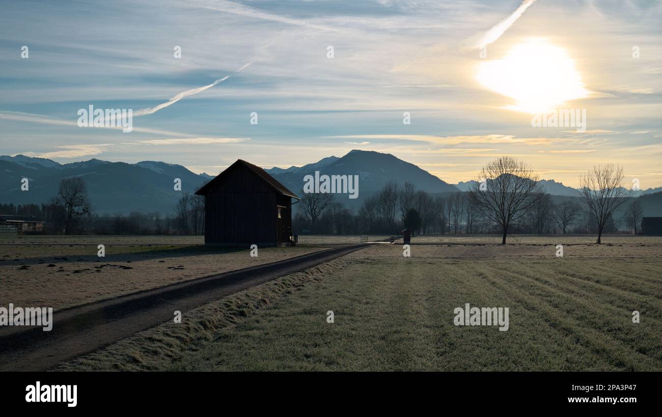 Wooden hut next to landscape path with trees and mountains in ...