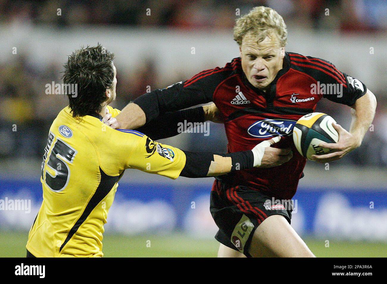 Crusaders Scott Hamilton looks to fend off the tackle of Hurricanes ...