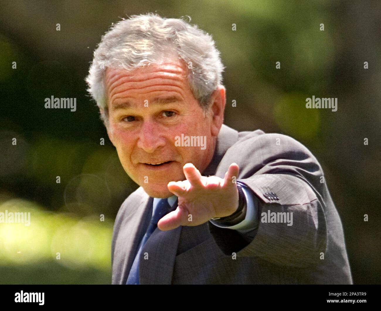 President Bush smiles and waves as he walks to board his helicopter ...