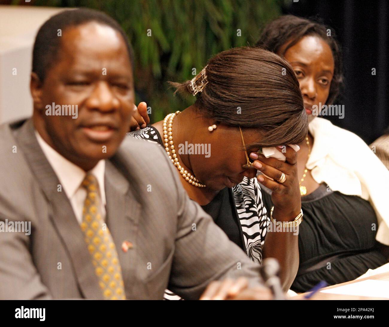 Jane Otieno, center, wipes hear tears as her husband, Kenyan public ...