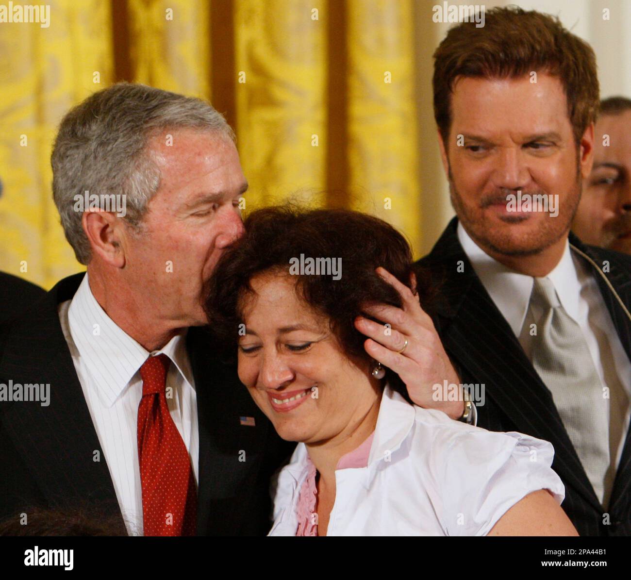 President Bush kisses Yamile Llanes Labrada, the wife of Cuban ...