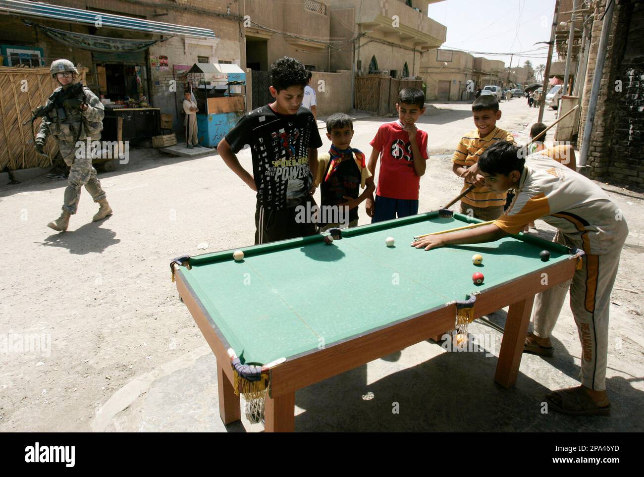 Iraqi boys play pool as a US soldier passes by during a joint foot ...