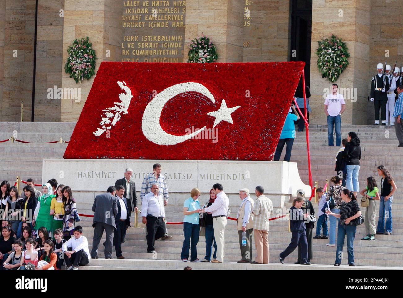 People and a military guard of honour are seen around a flag of Turkey ...