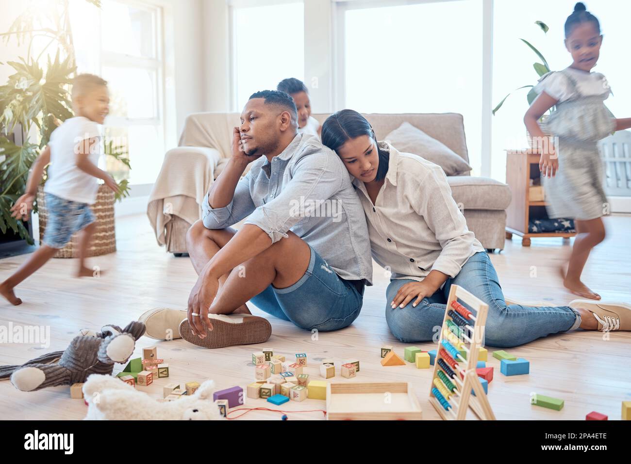 Tired parents, children playing in living room and running in with adhd ...