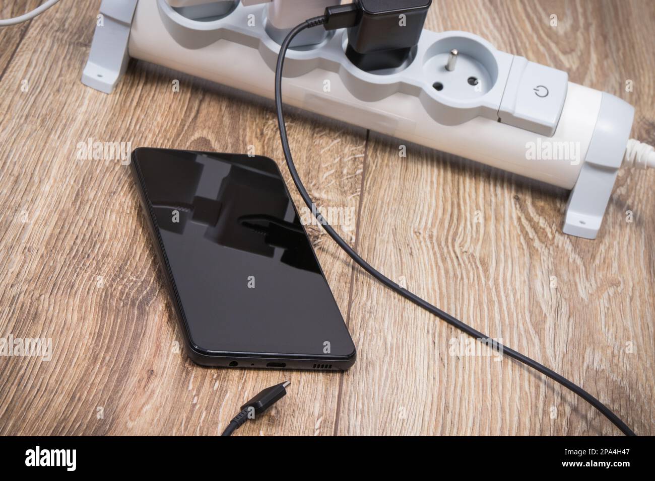 Smartphone, mobile phone and chargers connected to electrical power ...