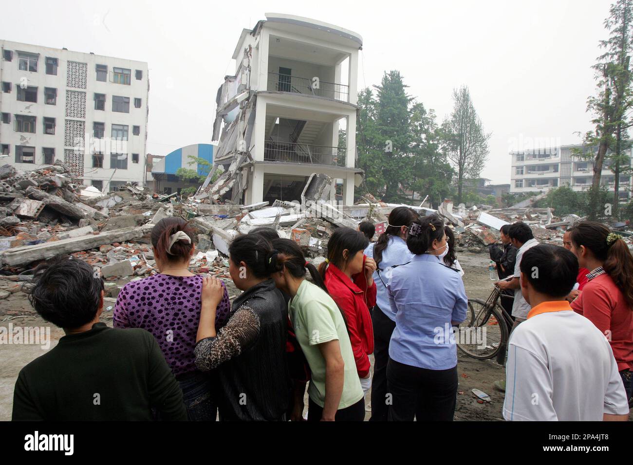 Residents look at the ruins of the Juyuan Middle School, in Dujiangyan ...