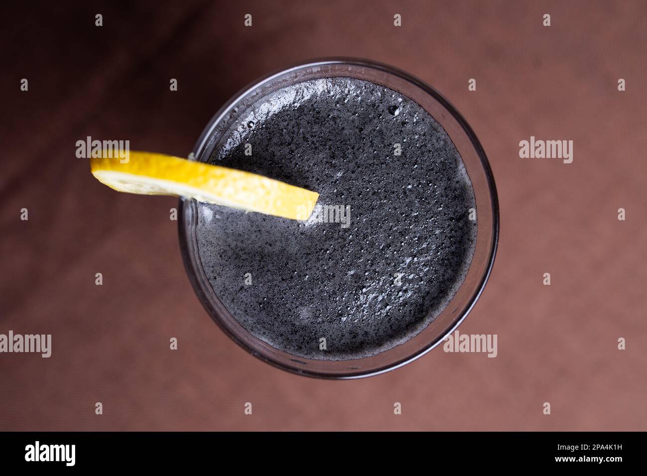 top view of an alcoholic drink with Coca-Cola and a slice of lemon in a ...