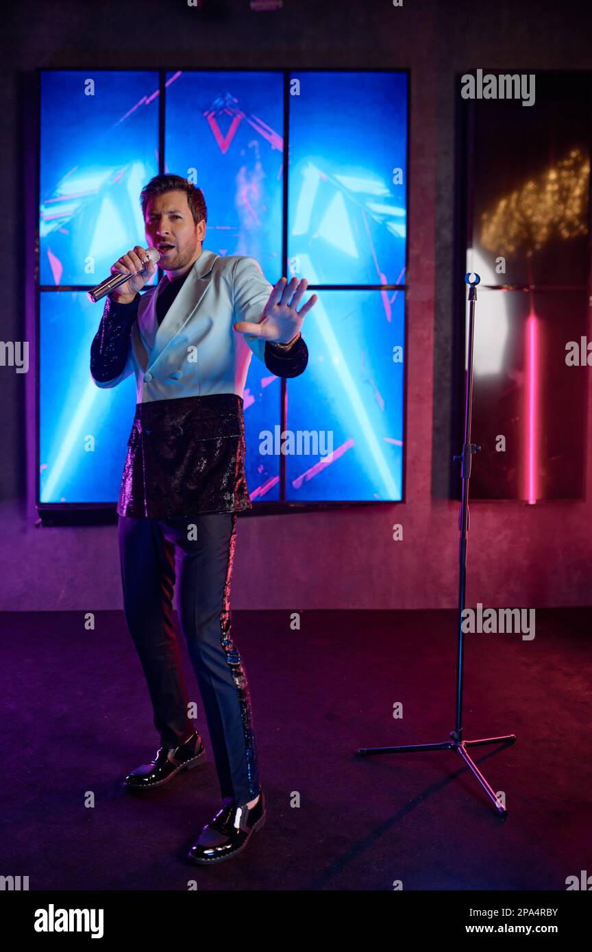 Male singer holding microphone standing and performing on stage Stock ...