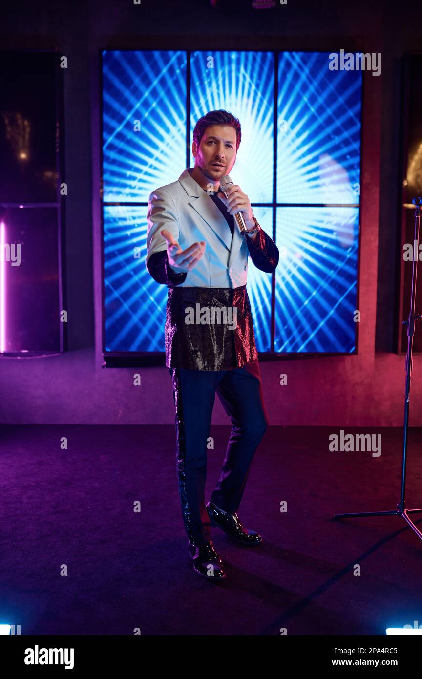 Male singer holding microphone standing and performing on stage Stock ...