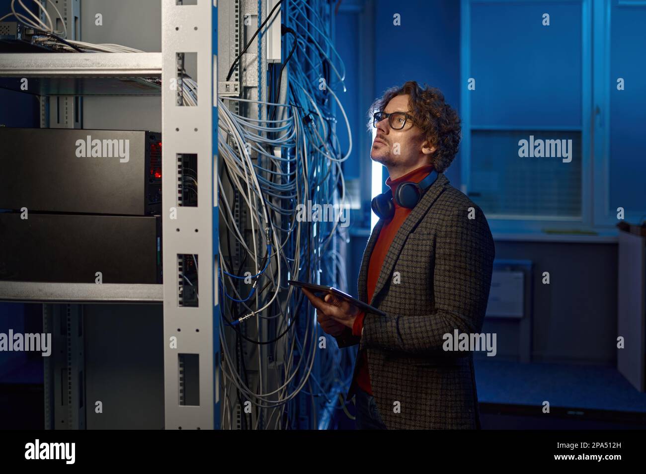 Male IT technical specialist makes a diagnosis in server room Stock ...