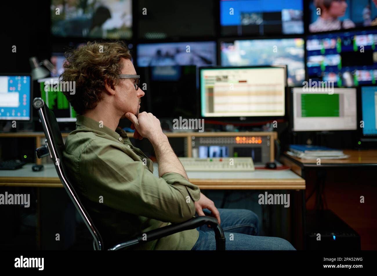 System administrator sitting in chair looking at computer screen in ...