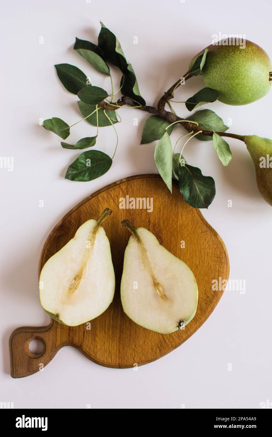 pears in a plate and slices of pears top view. wooden background with ...