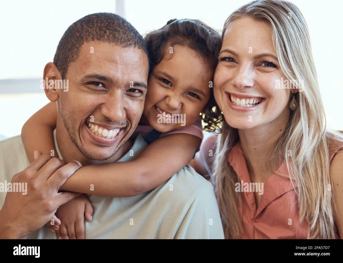 Multicultural parents child, portrait on sofa and happy mom and dad ...