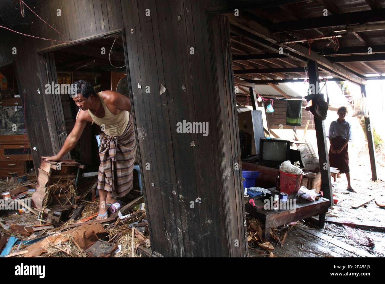 Myanmar man surveys the damage to his house at Mangalay village, in ...