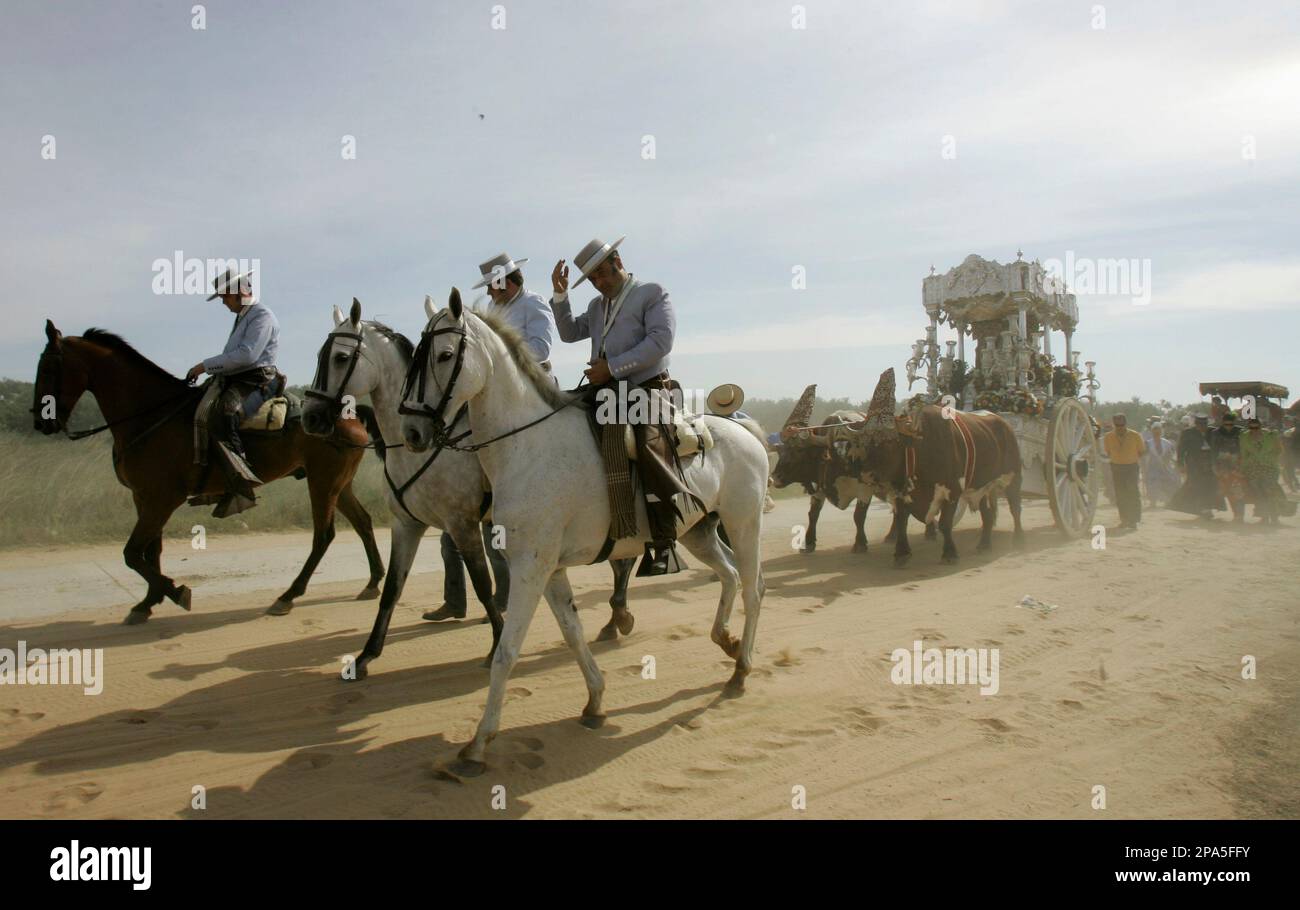 Pilgrims brace against the wind blowing dust while heading to the ...