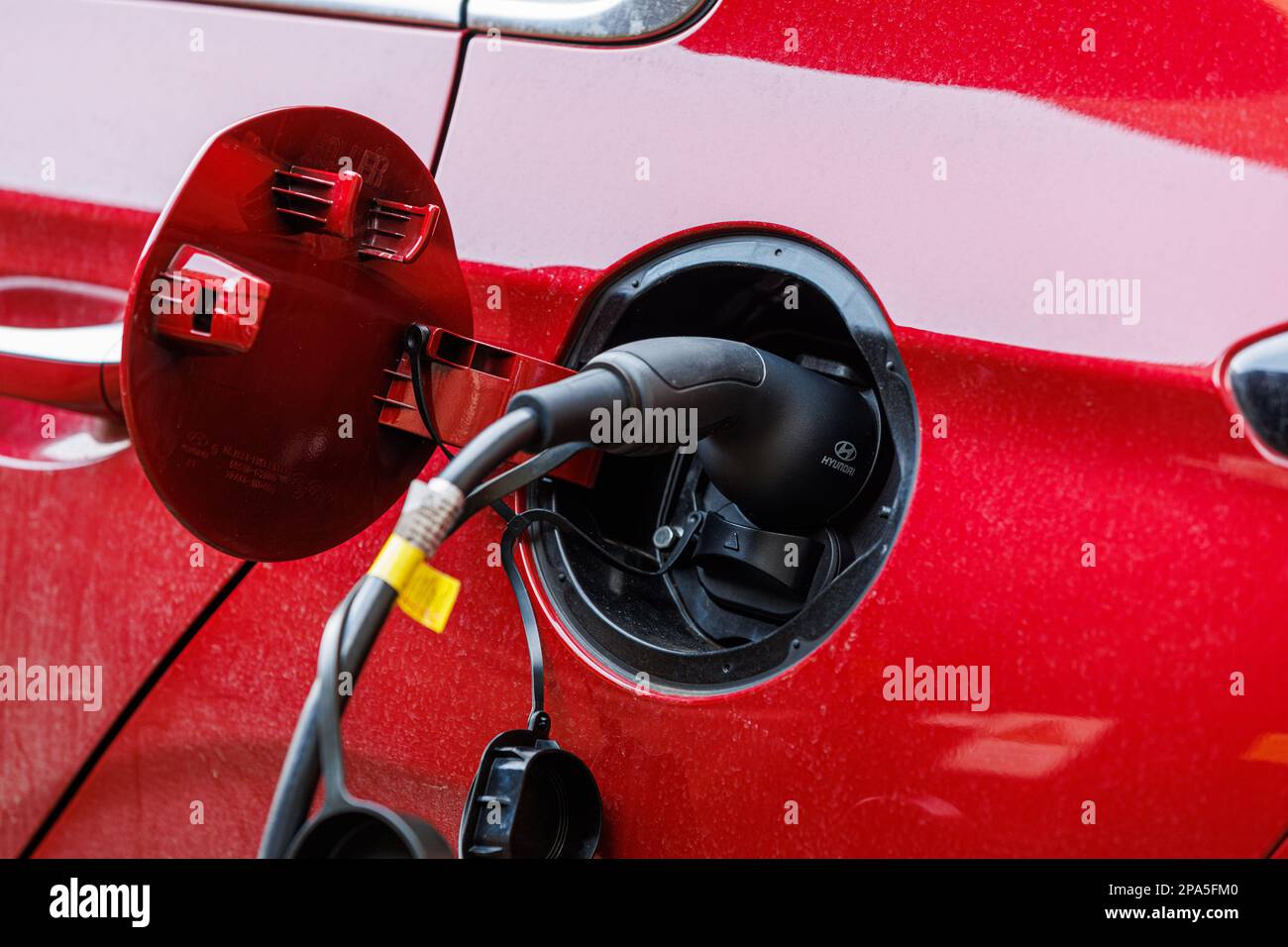 A red electric vehicle plugged in at a ChargePlace Scotland EV charging ...