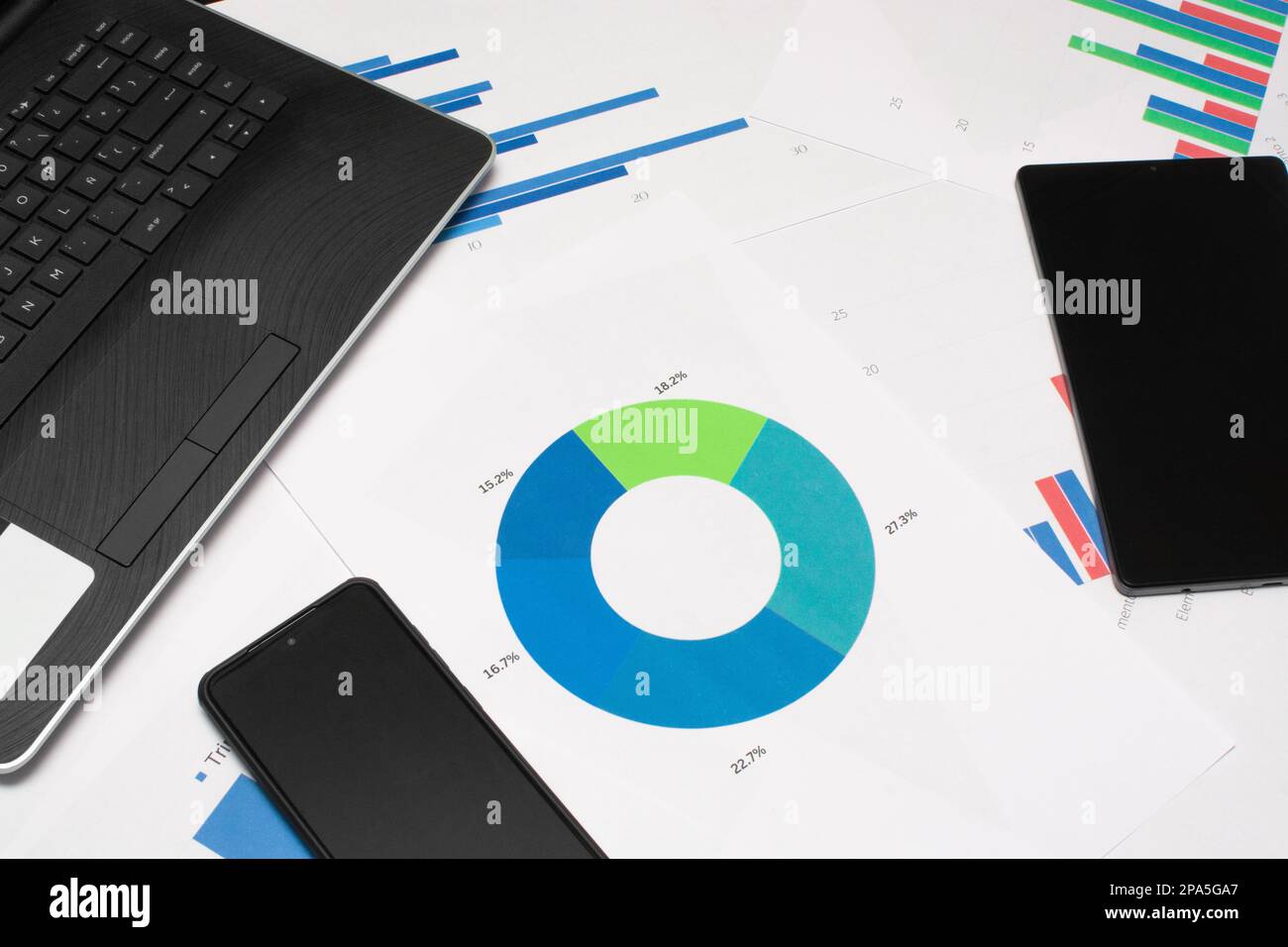A modern office setting featuring a cell phone, tablet, pie chart and ...