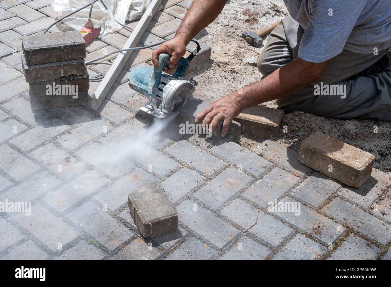 Brazilian construction worker using a concrete saw to cut the block ...