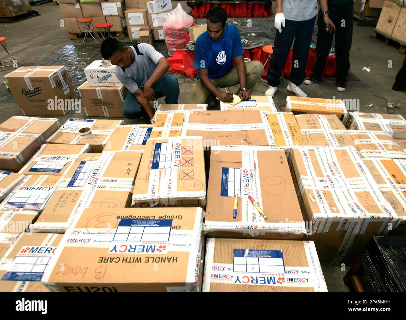 Malaysian aid workers pack relief supplies into boxes for cyclone ...