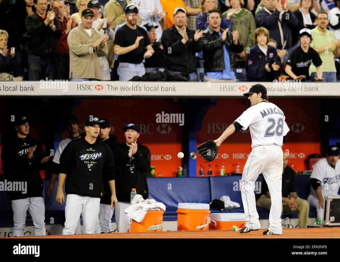 Toronto Blue Jays pitcher Shaun Marcum tosses the game ball as he walks ...
