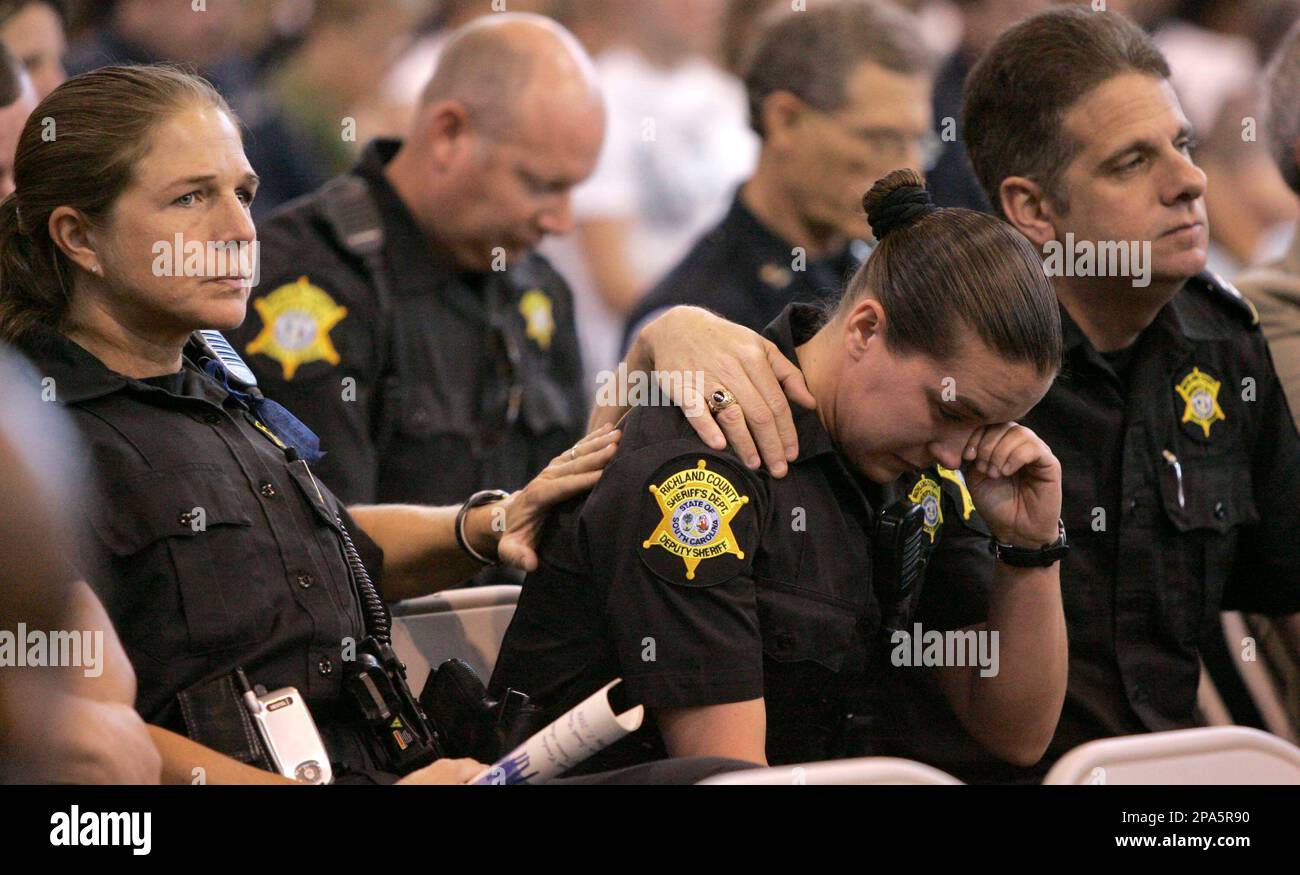 Richland County Deputy Kellye Hendrick, center, wipes her tears as she ...