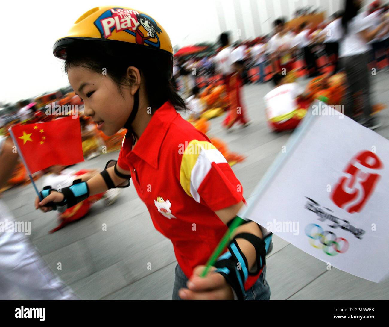 A Chinese child holds national and Olympic's flag as she skates during ...