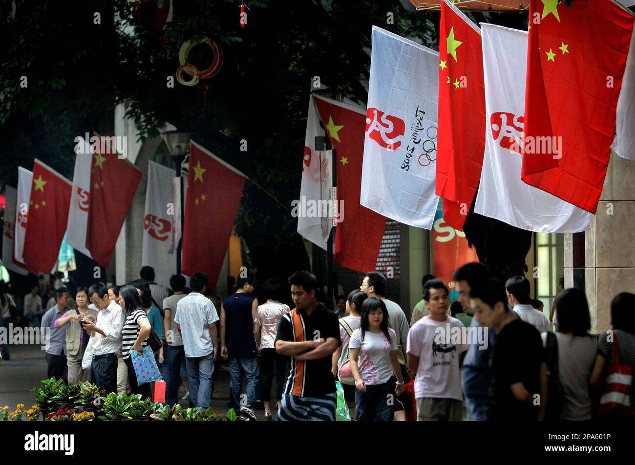 Tourists walks past national and Olympic flags on display at "Beijing ...
